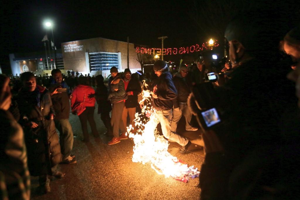 Ferguson protesters light another American flag on fire