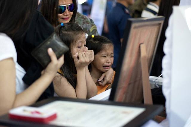 Children cry at the coffin of one of the SAF44. Photo by Noel Celis/AFP ...