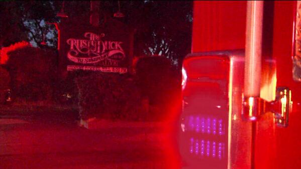 Grass fire ignites the shrubs around abandoned riverside Rusty Duck ...