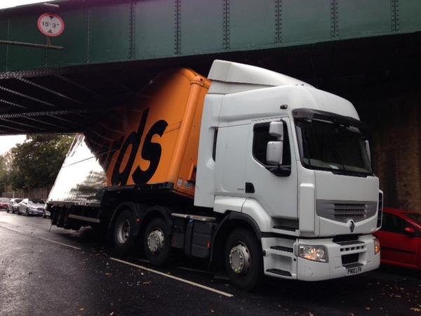 Lorry with slogan "we fit" wedged under bridge - ITV News