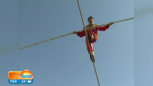 Chinese acrobat casually strolls across tight-rope suspended high in ...