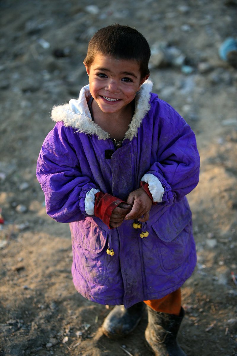 A smiling Afghan refugee boy in a refugee camp outskirts of Kabul ...