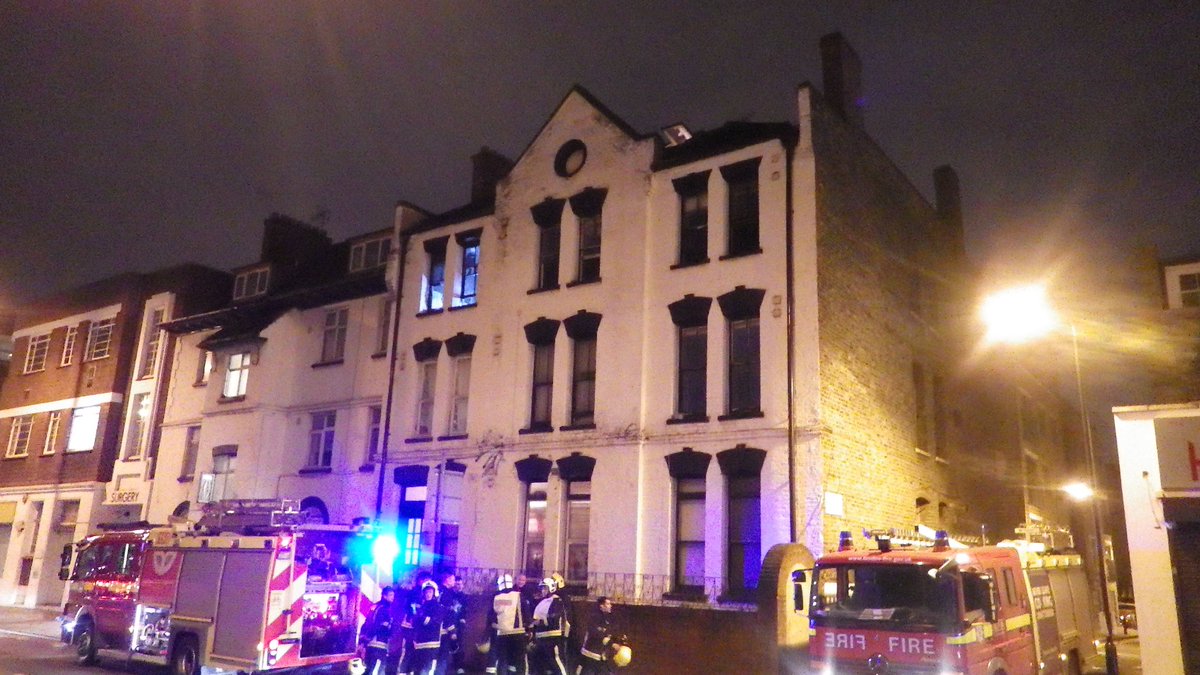 Fire crews wearing breathing apparatus led two man to safety from flat ...