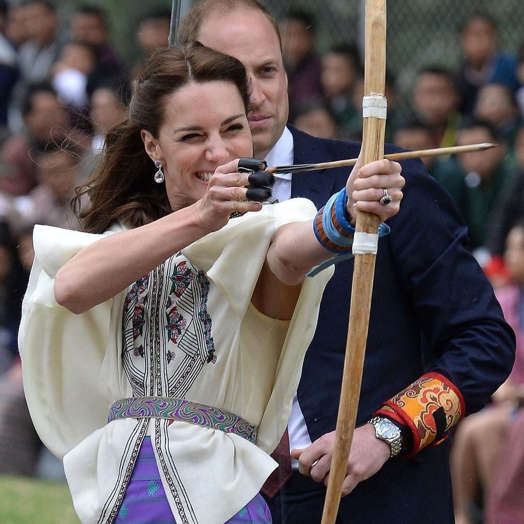 Kate 'Katniss' Middleton shoots a bow and arrow at an archery event as ...