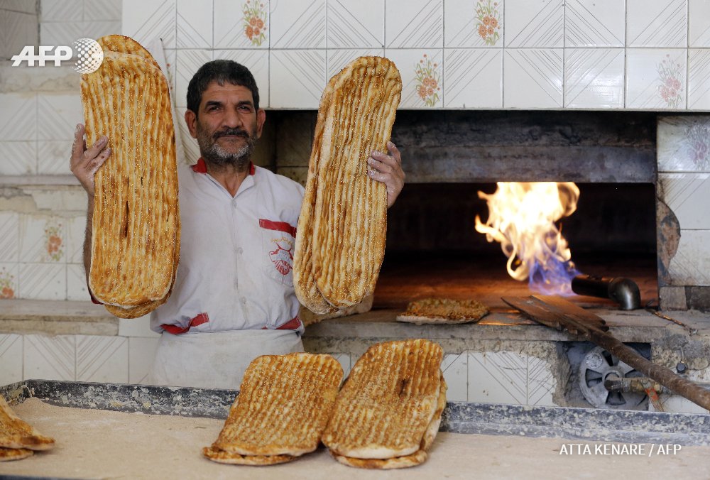 An iranian baker shows traditional bread, known as barbari, in tehran ...