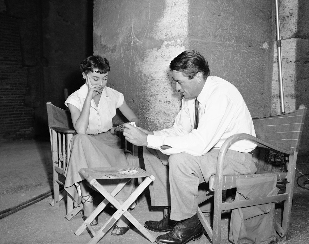 Audrey Hepburn playing cards with Gregory Peck on the set of 'Roman ...
