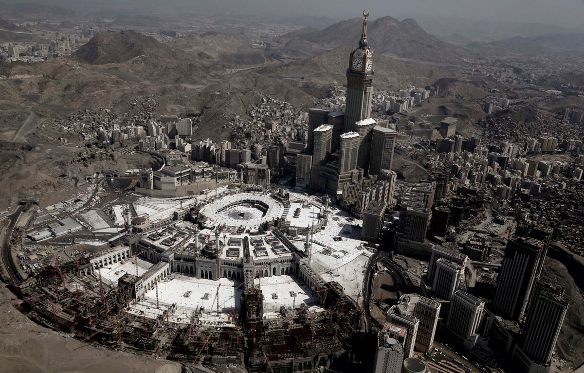 Aerial view of Abraj Al-Bait Towers with four-faced clocks over Kaaba ...