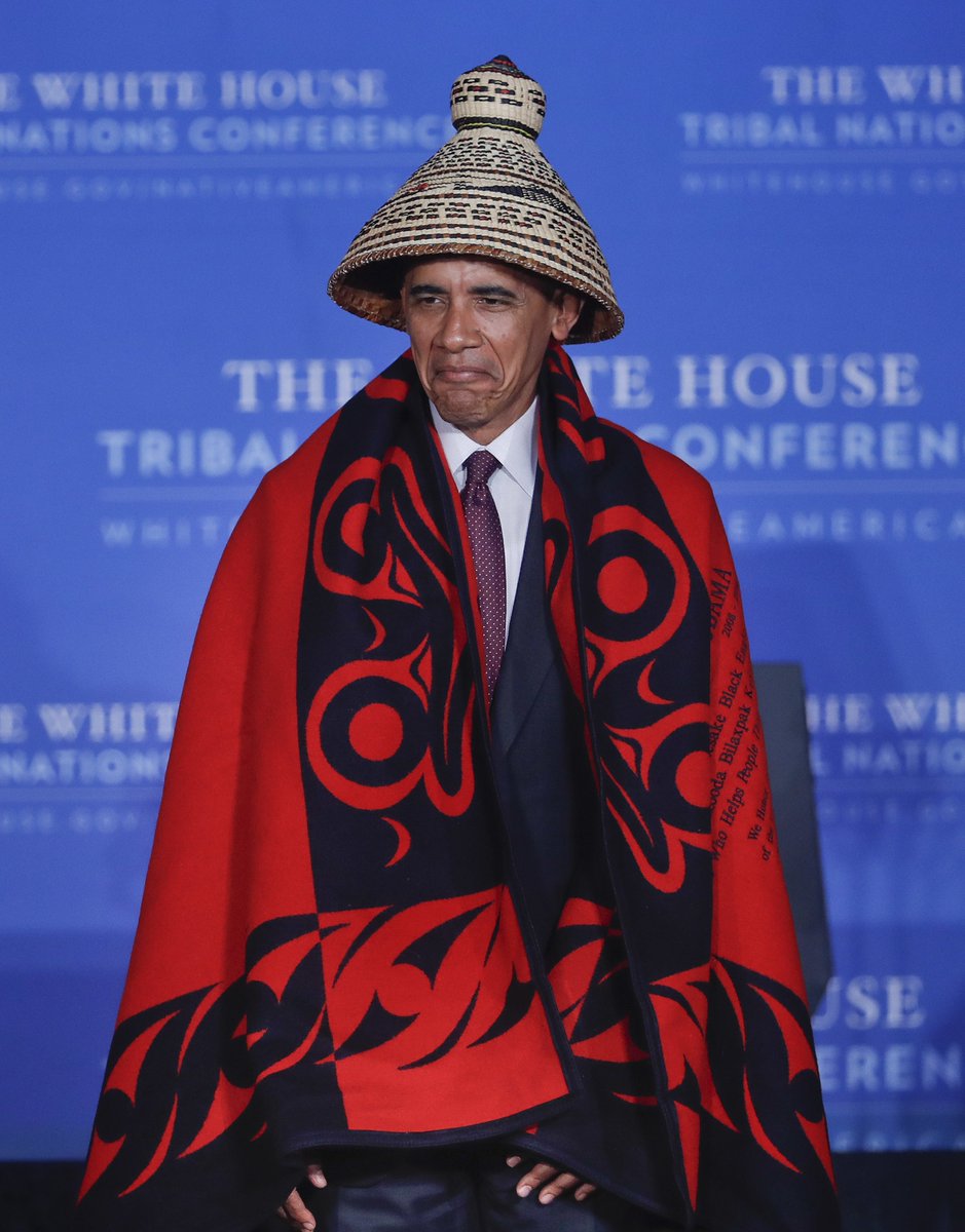 Barack Obama wears a ceremonial blanket and hat given to him during the ...