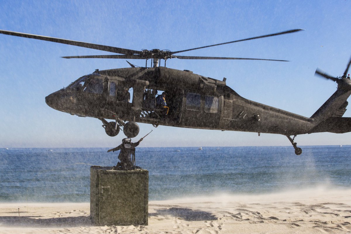 . police attach sling load cargo to a uh-60 black hawk during training ...