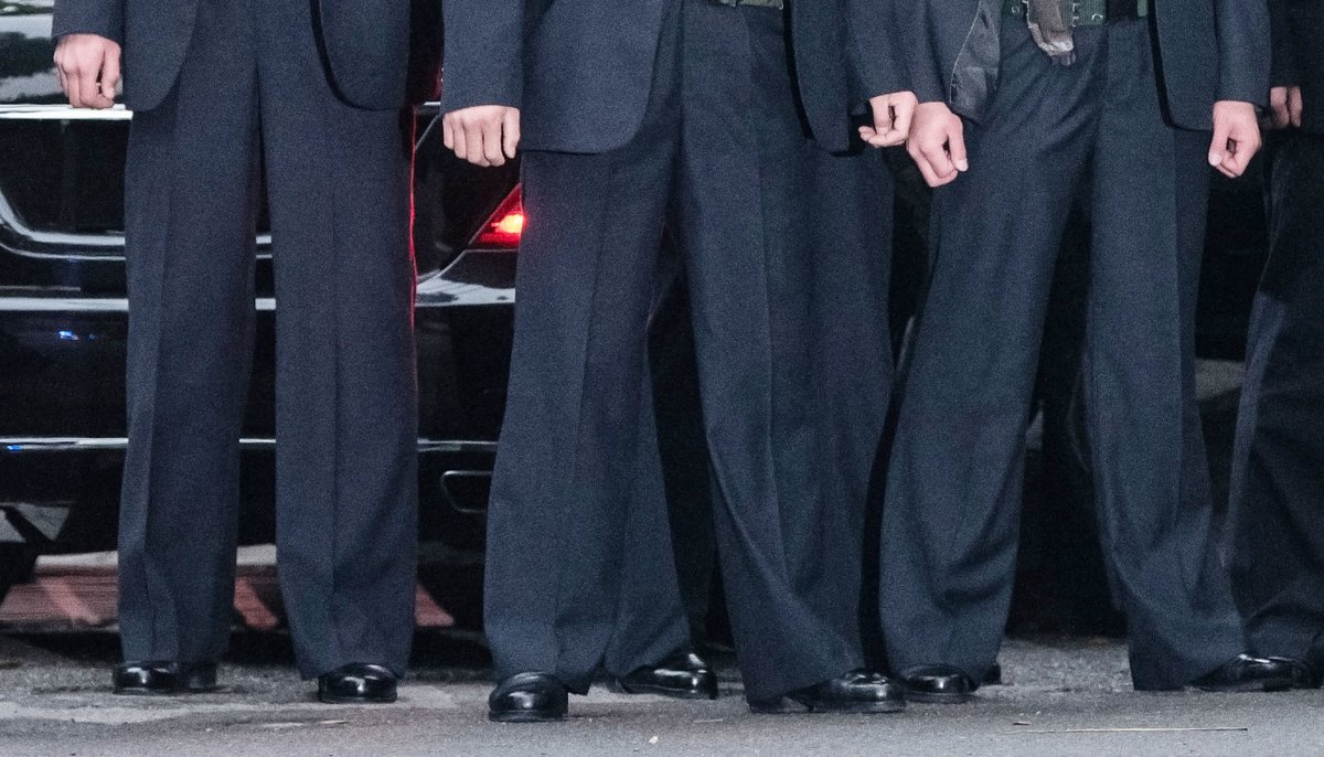 Bodyguards surround the car of North Korean leader Kim Jong-Un as he ...
