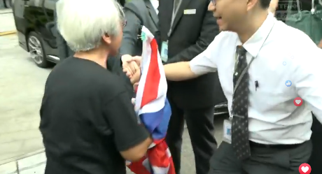 A car is trying to leave (?) govt HQ but met some protesters and the ...