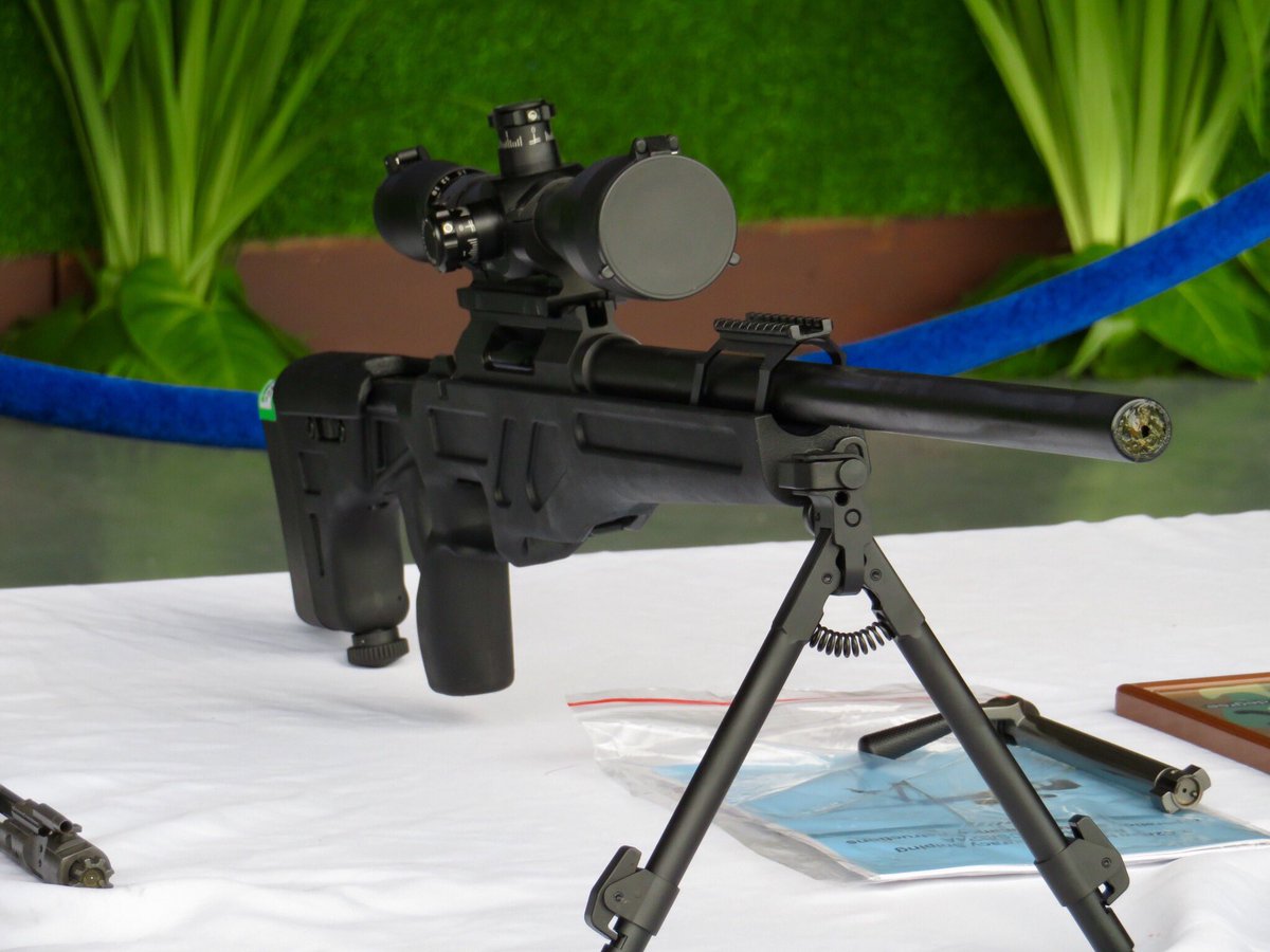 A sample of a chinese made sniper rifle, ak-47's and boxes of ammo ...