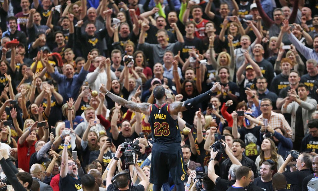 LeBron James jumps on the announcer's table and poses to the crowd ...