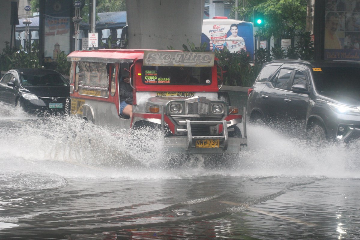 Vehicles brave the gutter deep flood along Taft Avenue Manila on Sunday ...