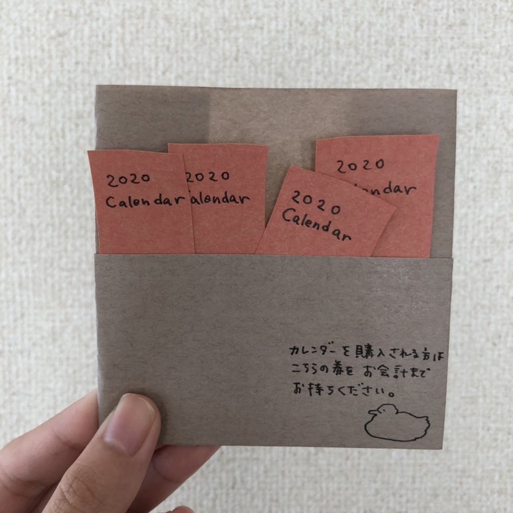 「カレンダー購入用の券にも落書きしました〜 有志展dadakoさんでは商品棚に見本だけ設置させていただきますので、横にある」昼間の漫画