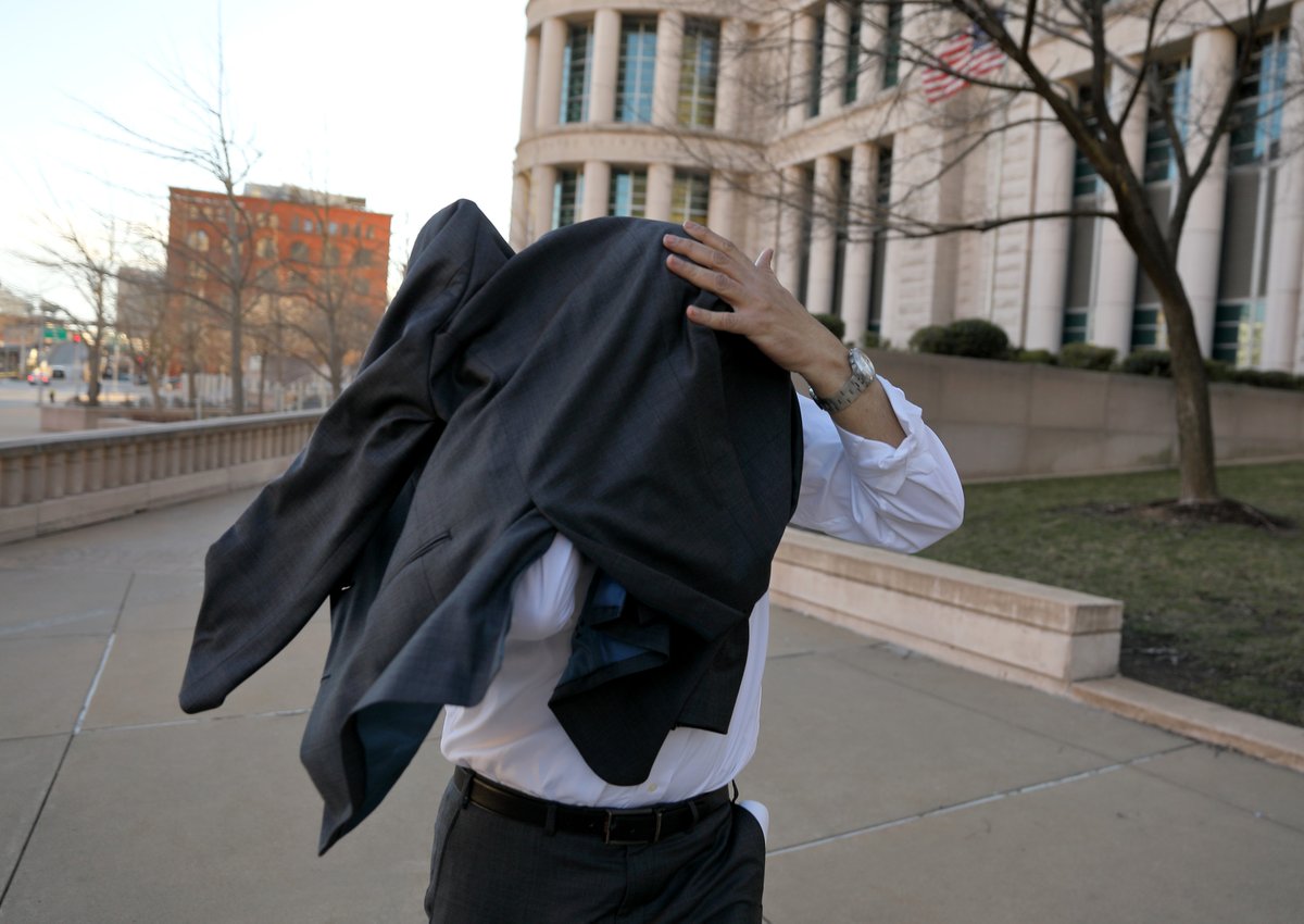 Dr. Asim Muhammad Ali hides his face as he leaves federal courthouse in ...