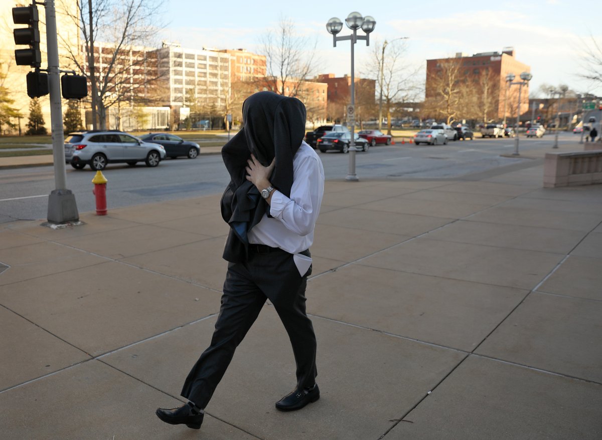 Dr. Asim Muhammad Ali hides his face as he leaves federal courthouse in ...