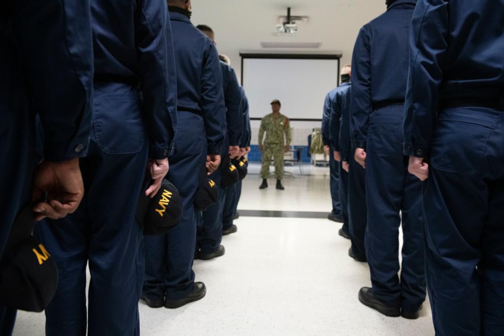 You're all official now. Recruits receive their Navy ball caps during a ...