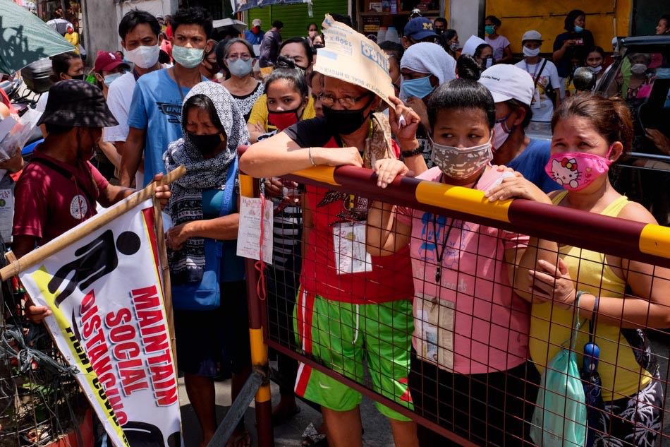 Residents line up outside a covered court in Barangay Payatas, Quezon ...