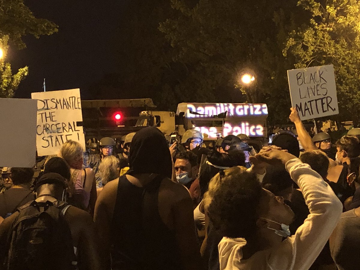 Some “Demilitarize the police” projection from the crowd of protesters ...