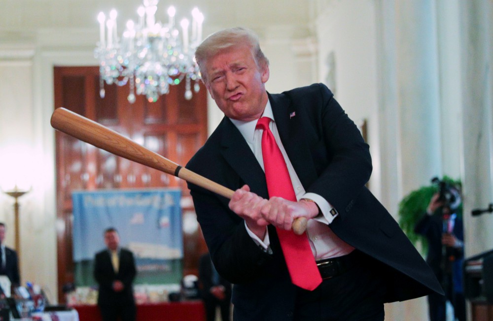 U.S. President Donald Trump swings a wooden baseball bat as he attends ...