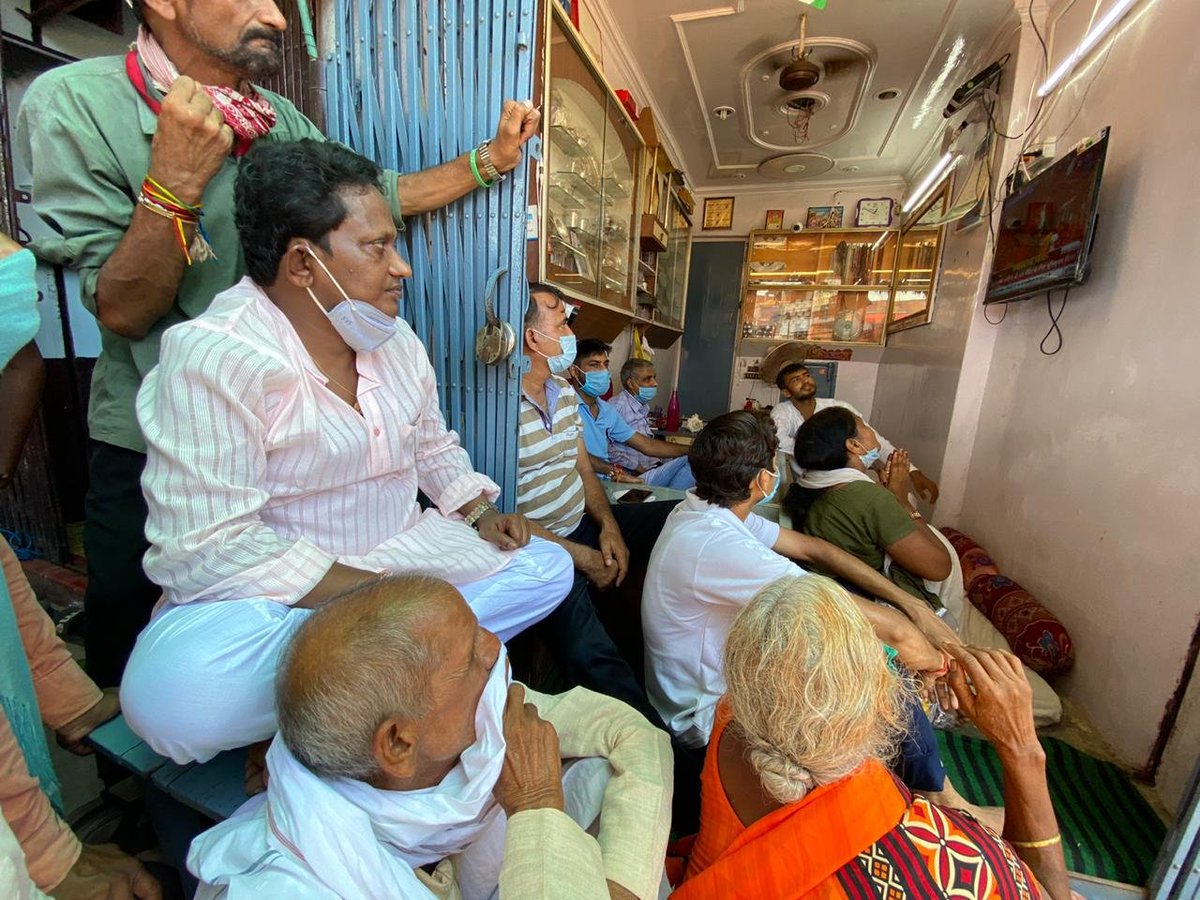 Group of people crammed in a shop watch the RamTemple ground-breaking ...