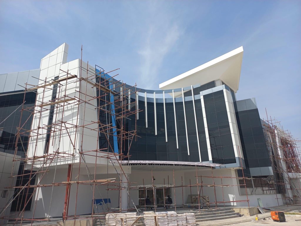 Contractors detach scaffolding from the ongoing construction of Kano ...