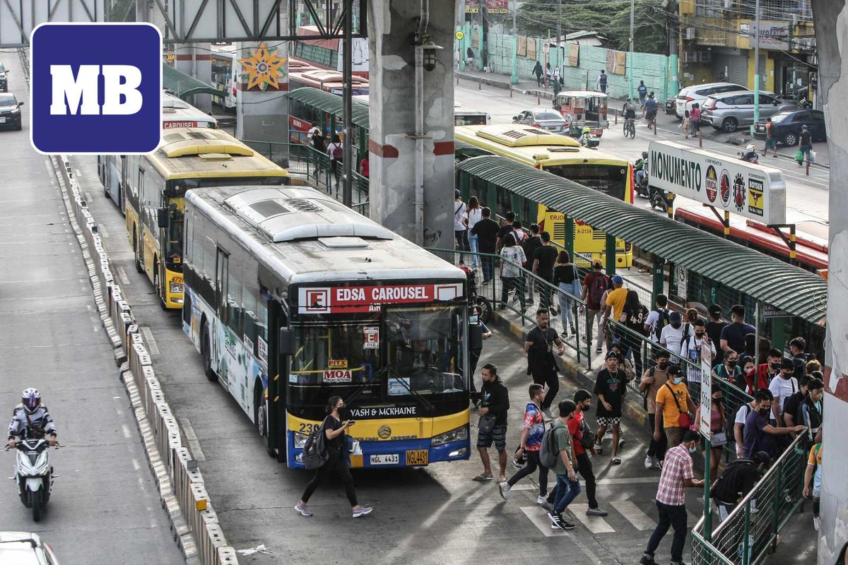 Commuters line up to ride buses at the Monumento Bus Carousel Terminal ...