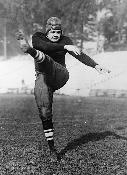 Babe Ruth punting a football.
