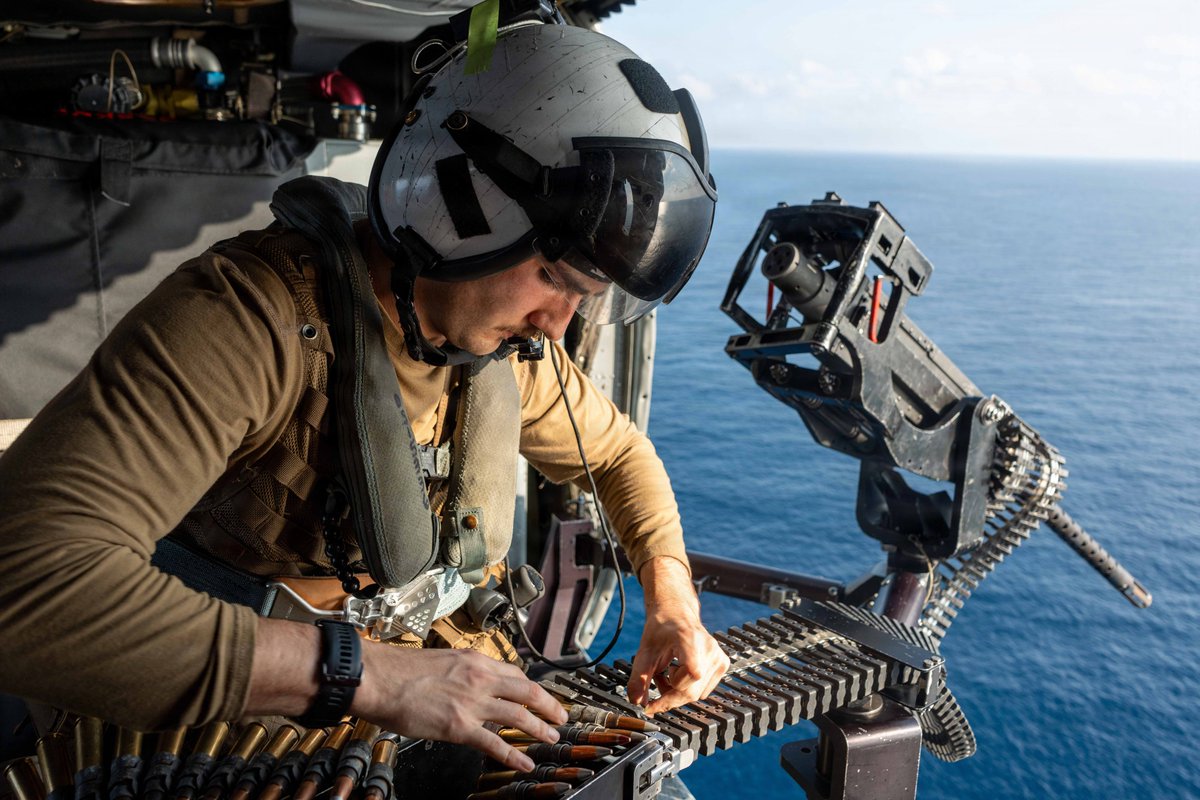 Naval aircrewmen conduct a live-fire exercise from an MH-60S Sea Hawk ...