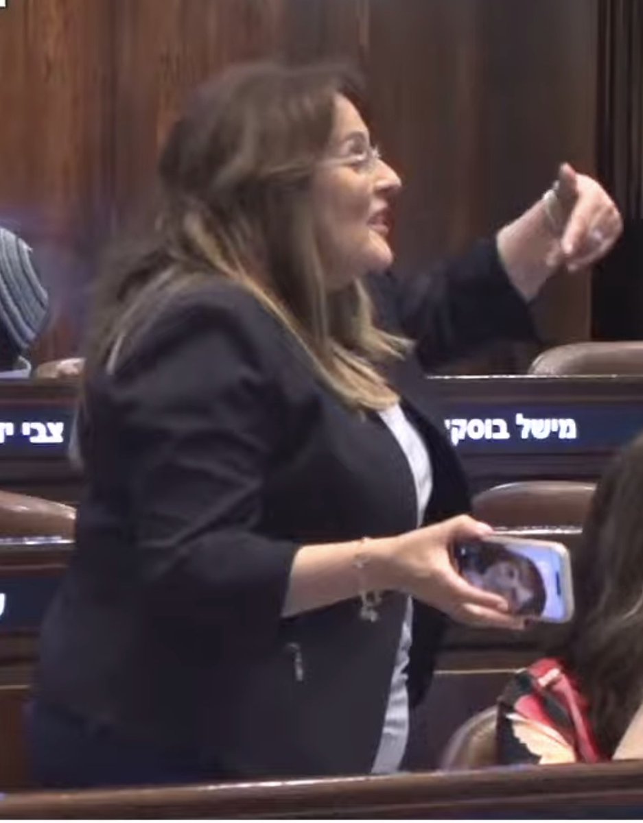 גילה גמליאל, עצבנית משהו, יוצאת מהקלפי לצד שבו יושבים ראש הקואליציה ...